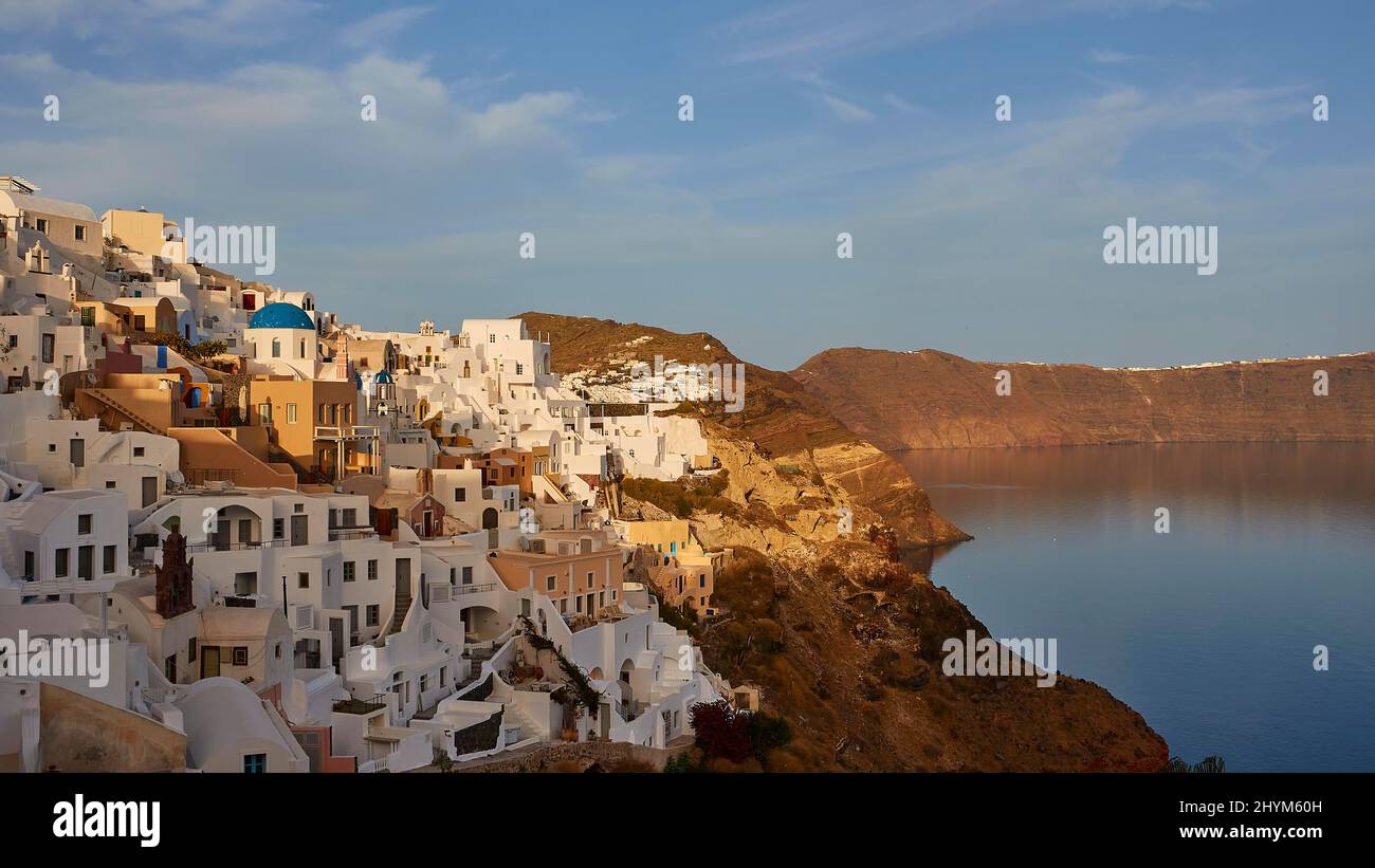 Evening light, view of the colourful houses of Oia, sky light blue with ...