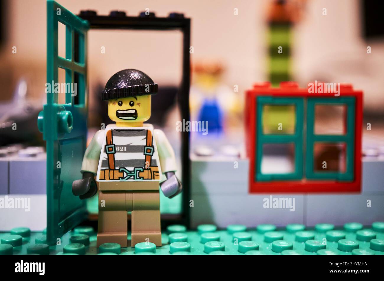 Closeup of a scared Lego toy figurine prisoner standing in front of an ...
