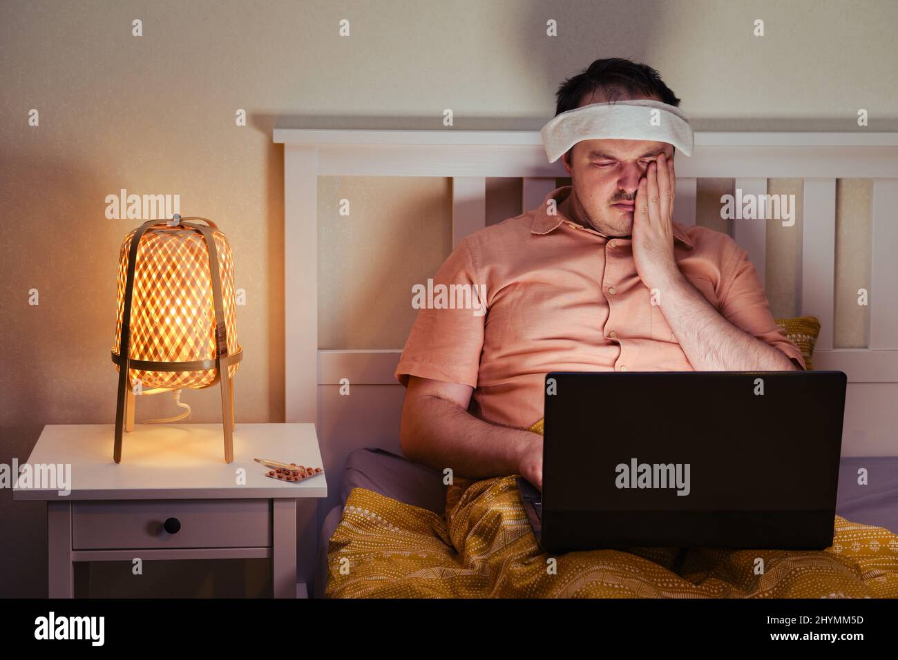 Adult sick man crying holding his sore head while lying on bed with ...