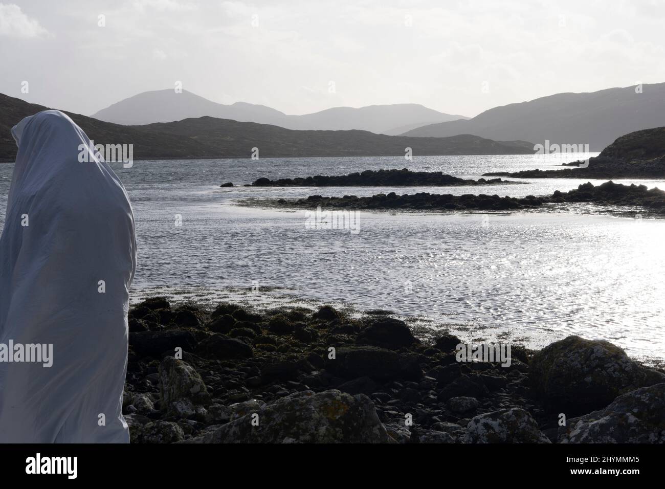 A spooky ghost in a sheet. Standing by a lake with mountains. Scotland ...