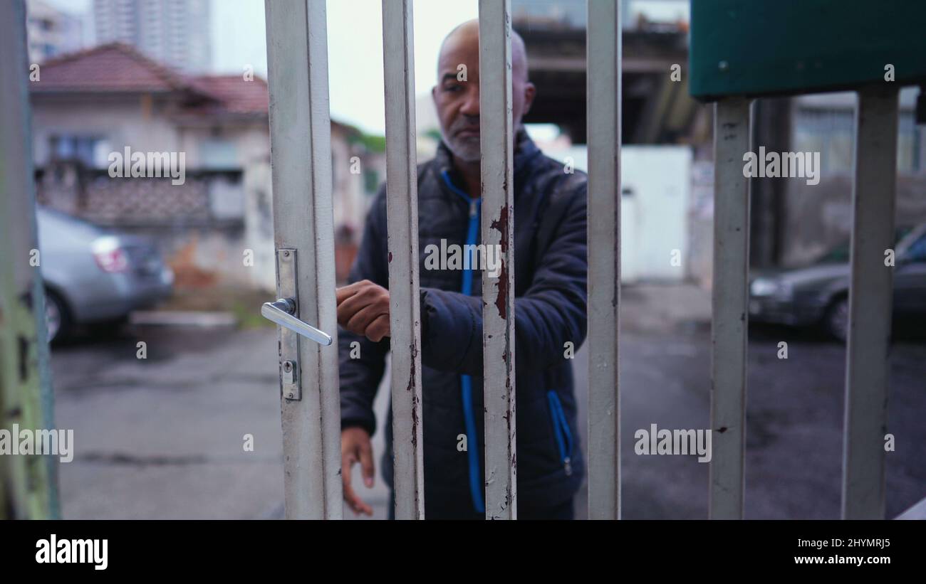 A Brazilian man closing front door going outside in the street person ...