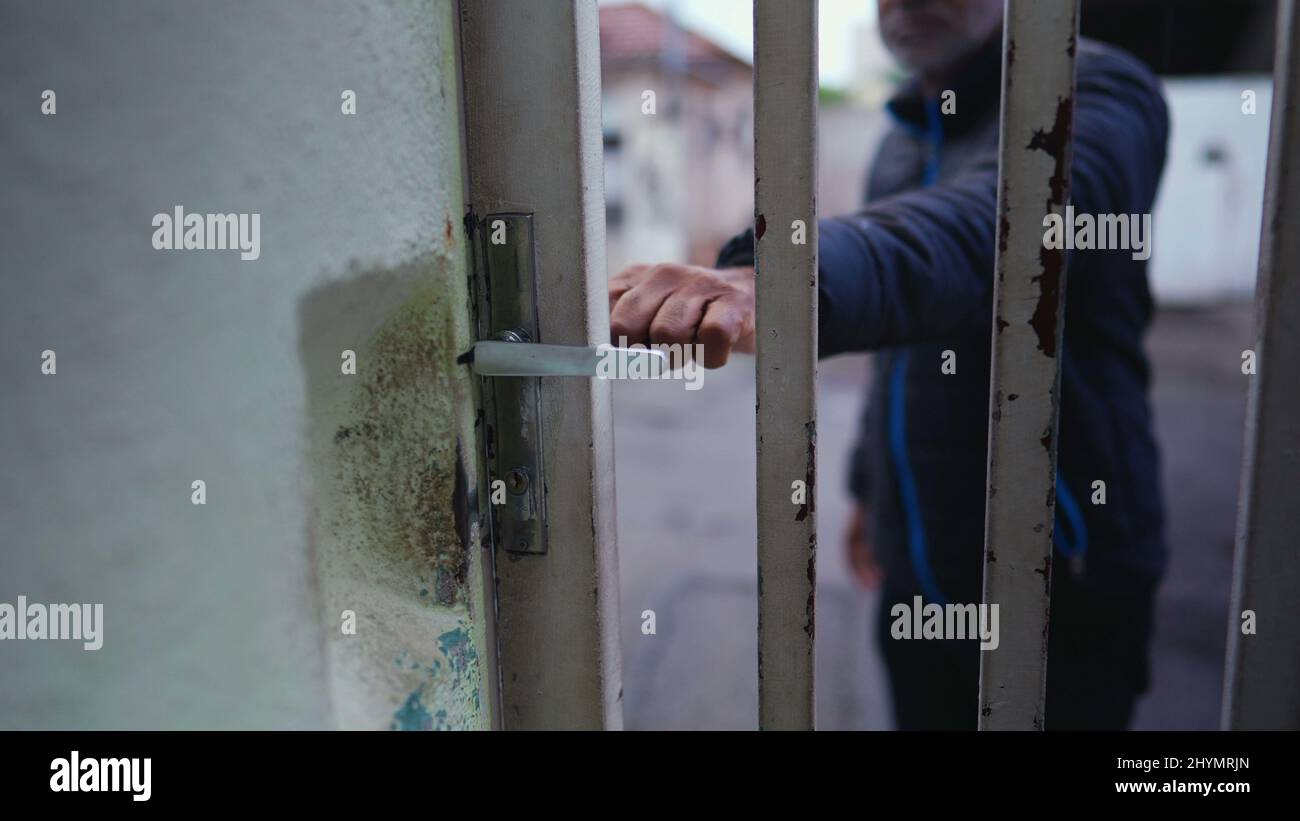A Brazilian man closing front door going outside in the street person ...