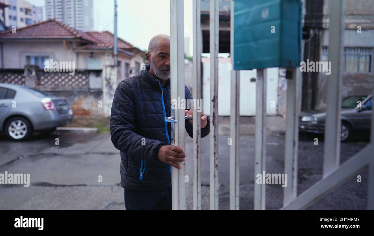 A Brazilian man closing front door going outside in the street person ...