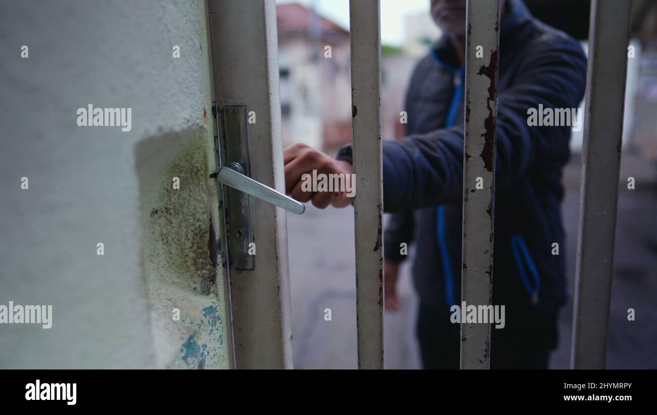 A Brazilian man closing front door going outside in the street person ...