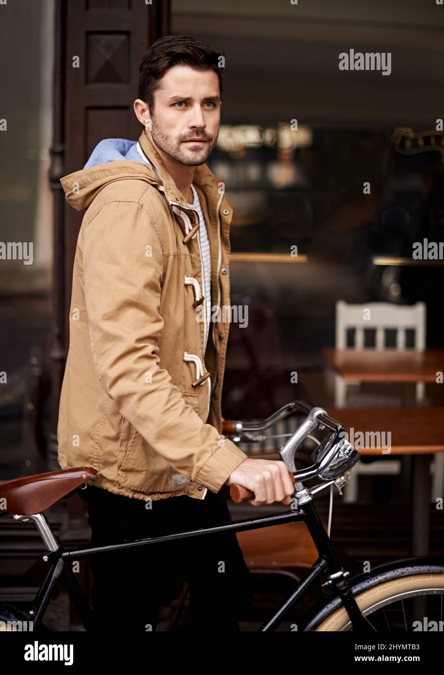 Taking a cycle tour of the city. Cropped shot of a young man pushing ...