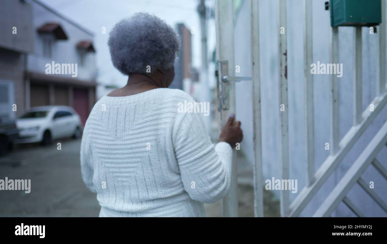 A senior black woman leaving house person opening front door Stock ...
