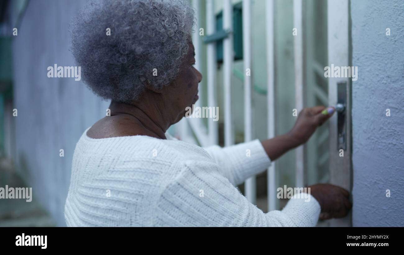 A senior black woman leaving house person opening front door Stock ...