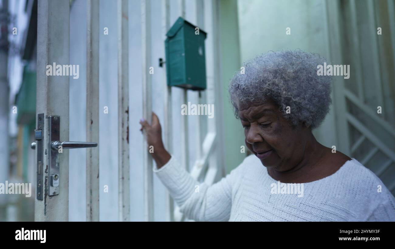 A senior black woman leaving house person opening front door Stock ...