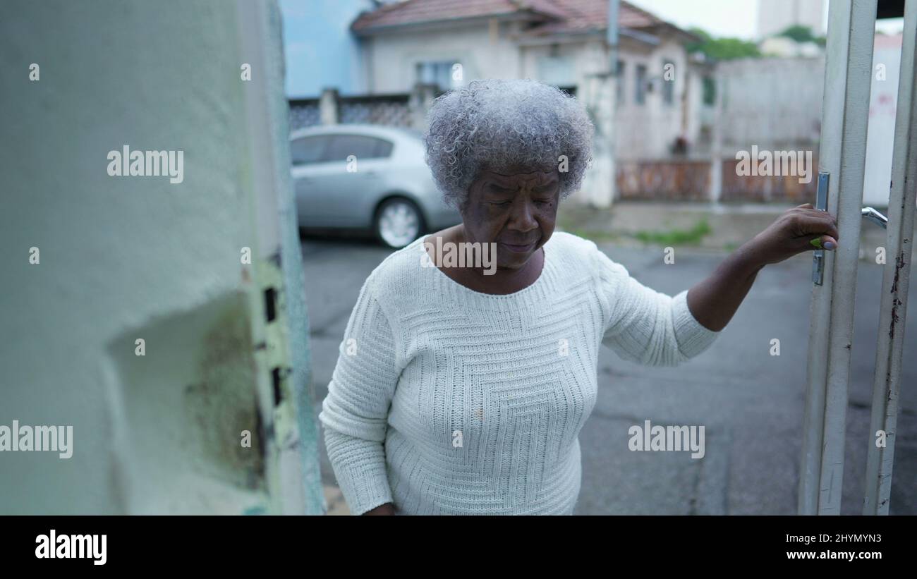 A senior woman opening door gate Stock Photo - Alamy