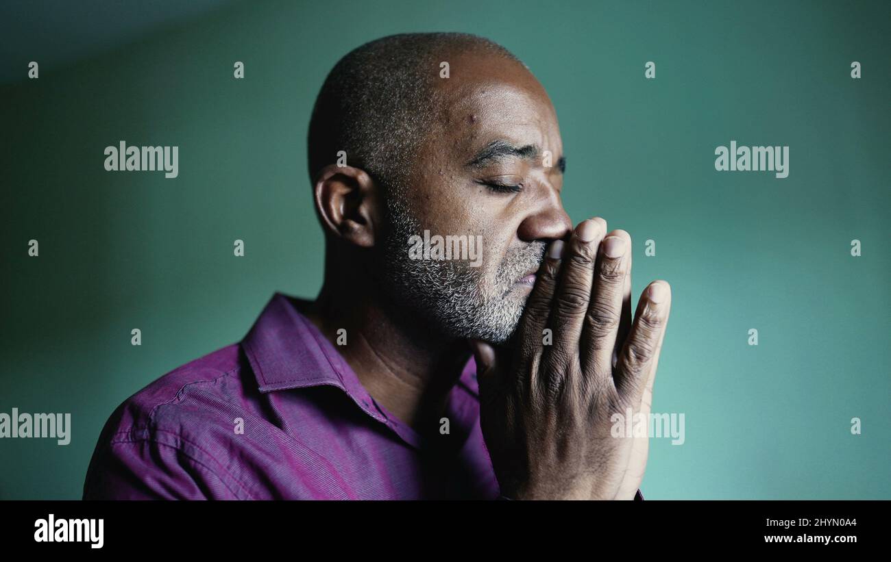 A south american senior black man praying to God. A spiritual black man ...