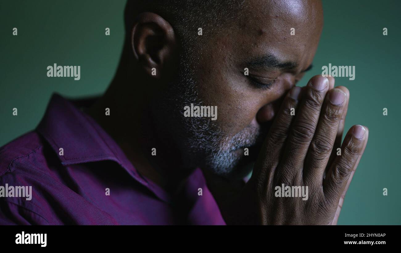 A south american senior black man praying to God. A spiritual black man ...