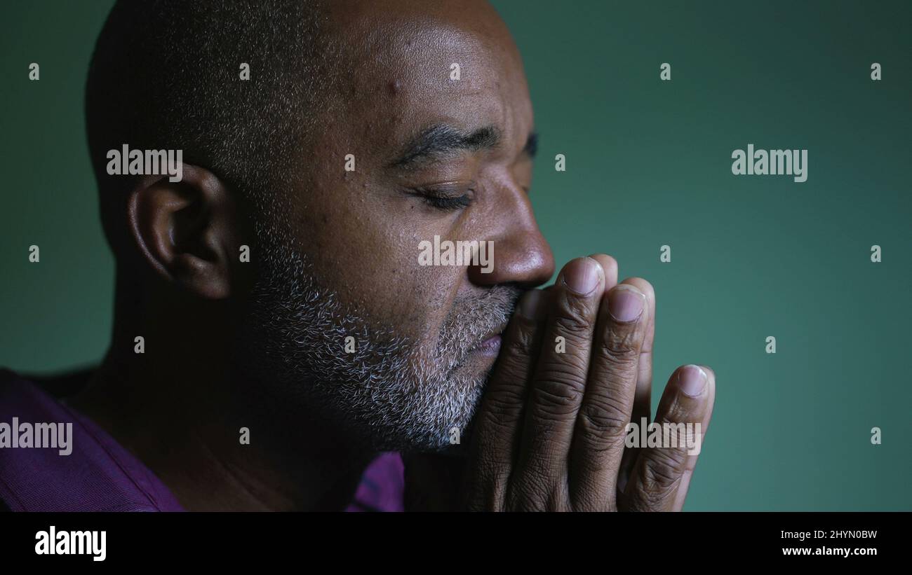 A south american senior black man praying to God. A spiritual black man ...