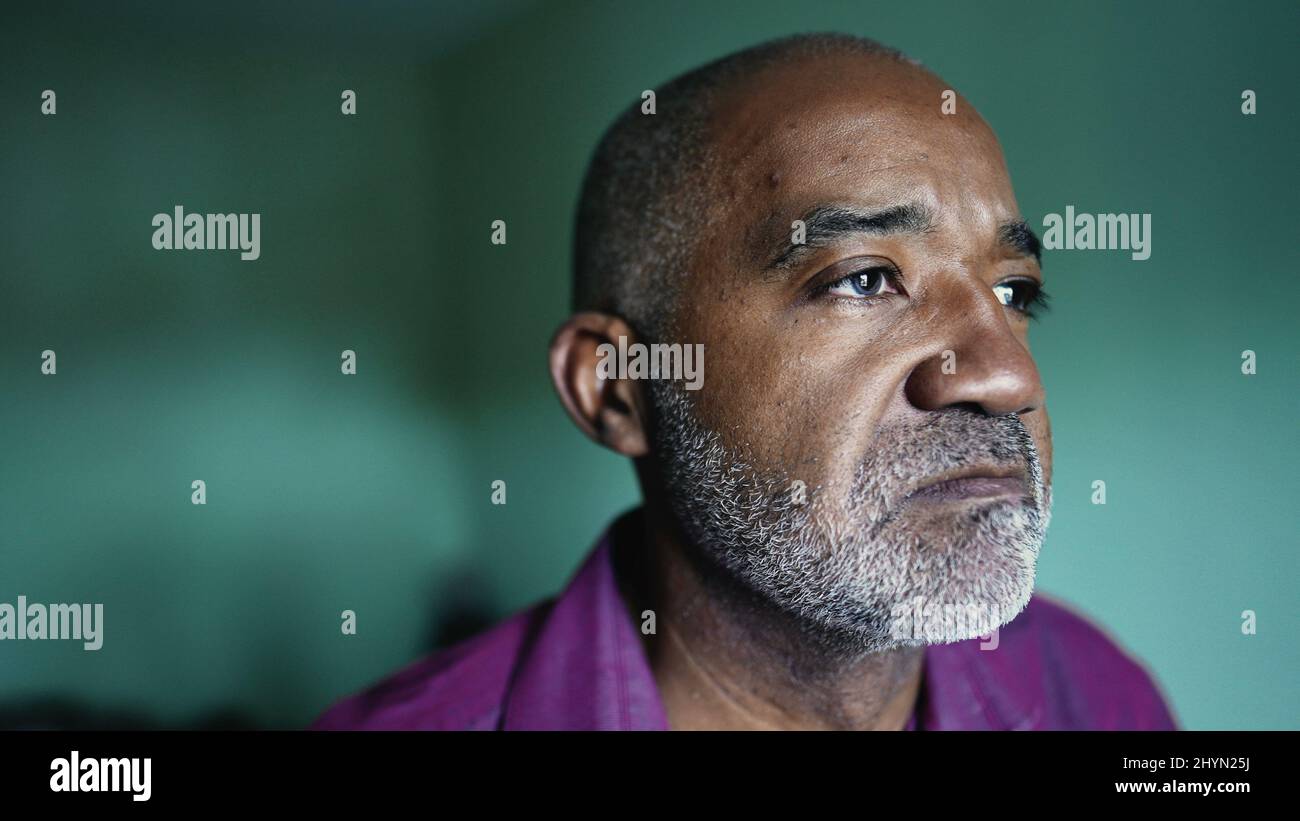 A thoughtful African man in bedroom thinking about life during middle ...