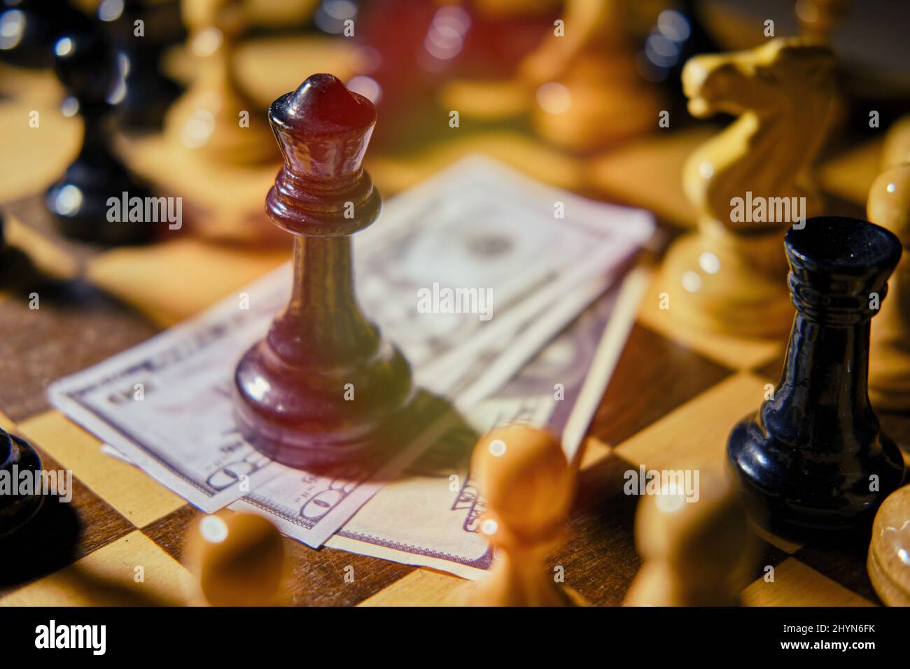 Money in US dollar bills on an old chessboard with retro chess pieces ...