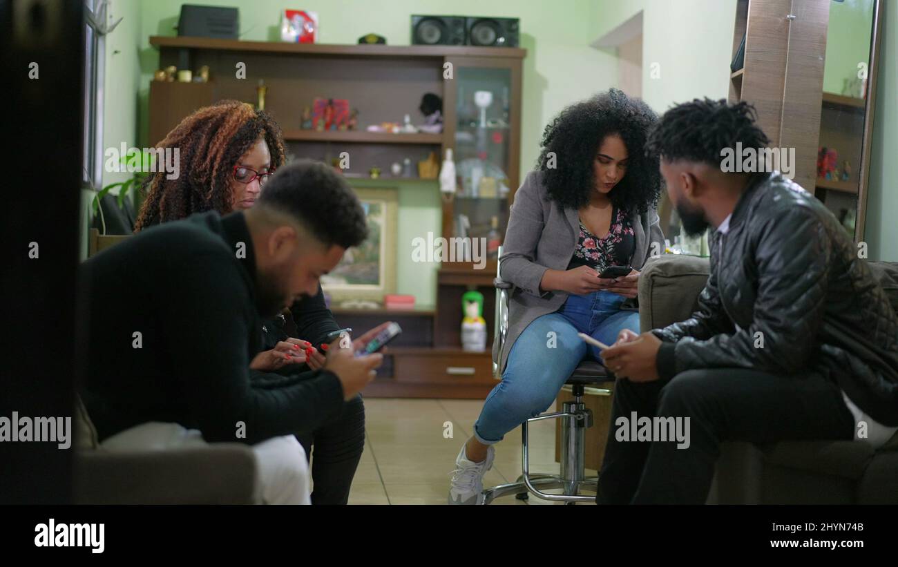 Candid group of friends staring at phones living in isolation bubbles ...