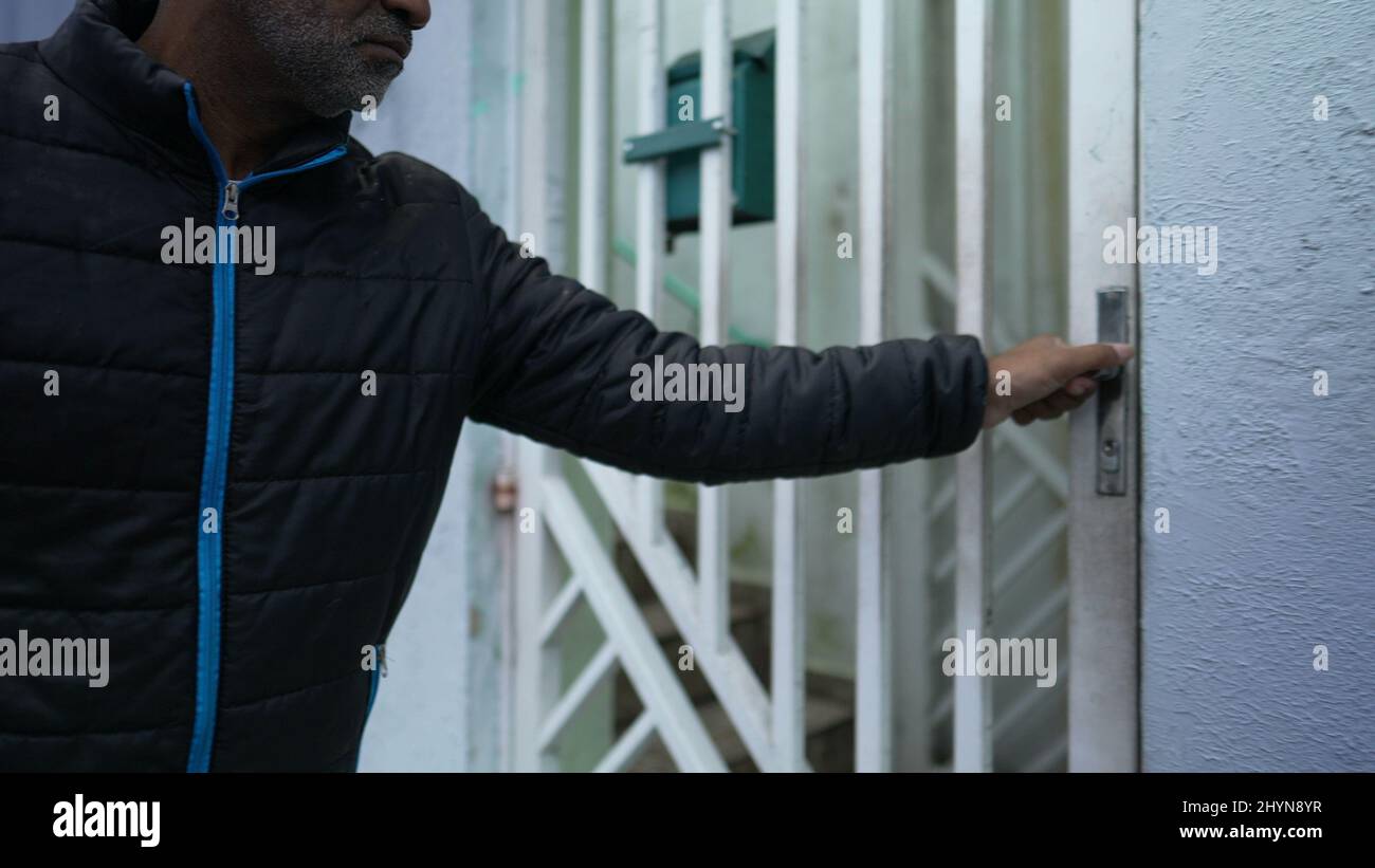 Person arriving home opening door a senior man opens entrance gate ...