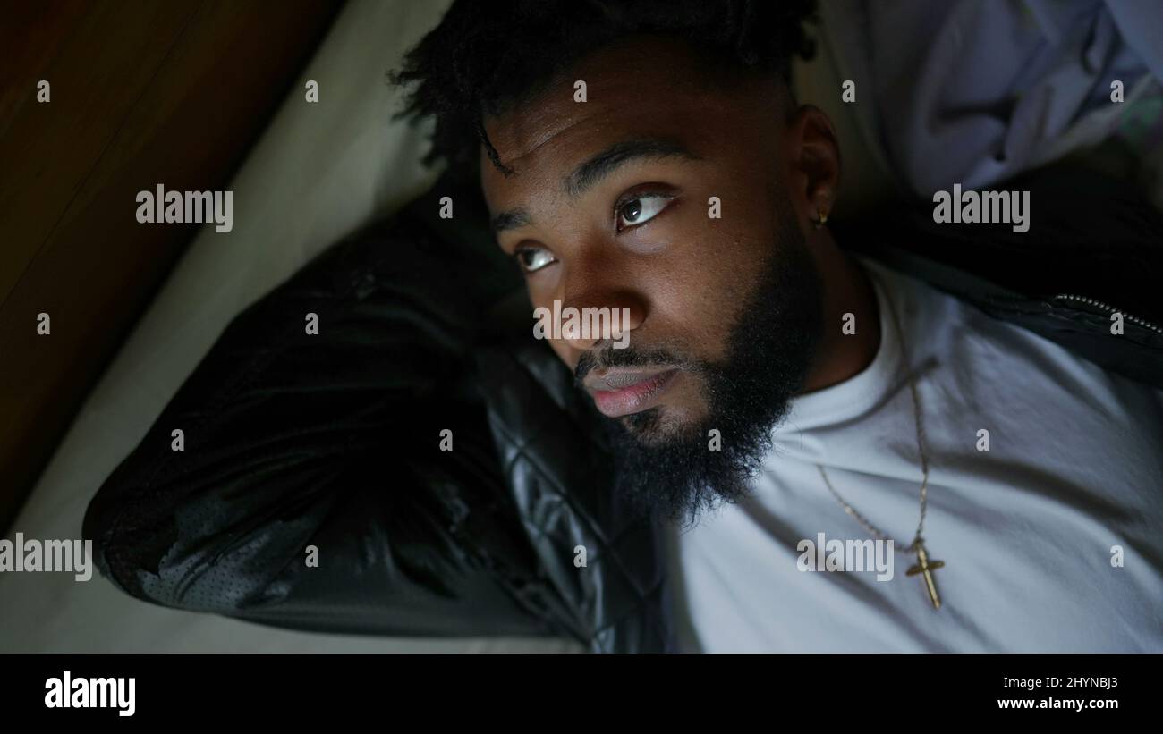 A pensive black man lying down in bed a resting young African man daydreaming Stock Photo - Alamy