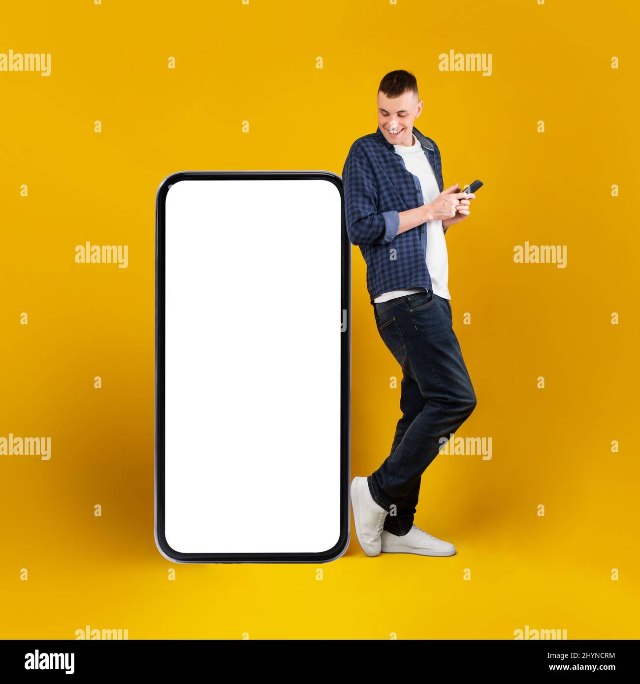 Man Near Big Cellphone Standing Using Phone On Yellow Background Stock ...