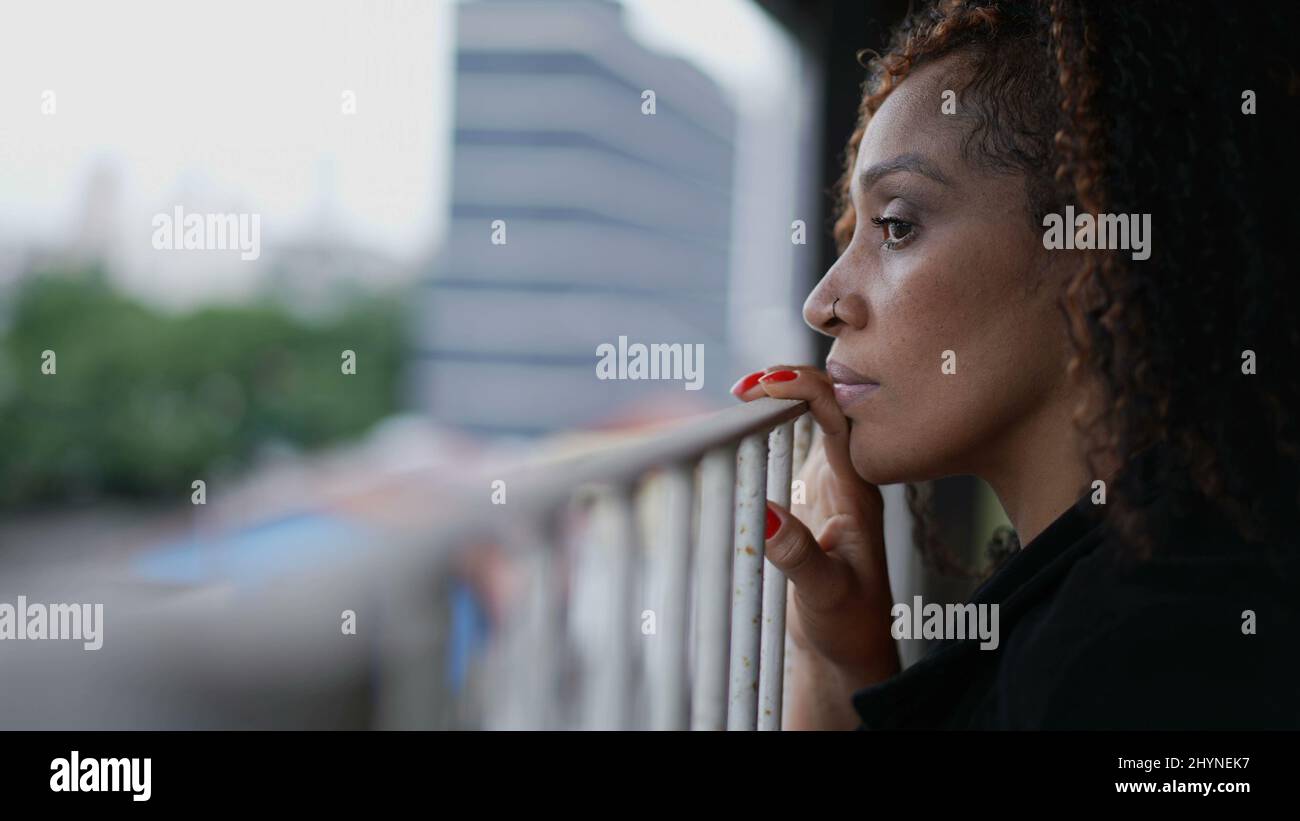 Person observing the street outside from home balcony a black woman ...