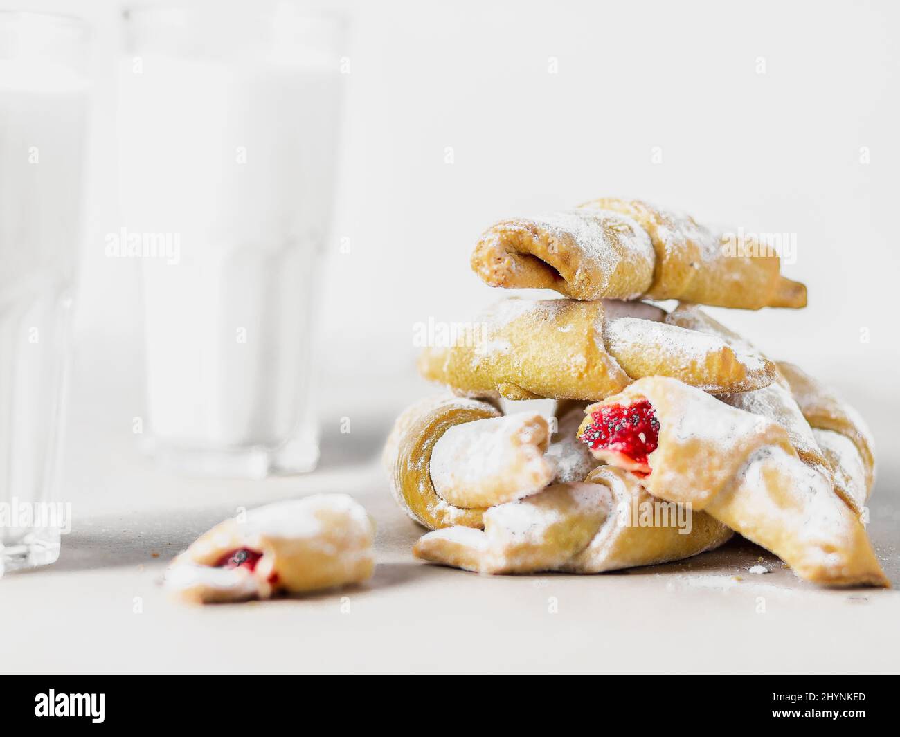 Stack of jam-filled, bow-tie cookies with a white, blurry background ...