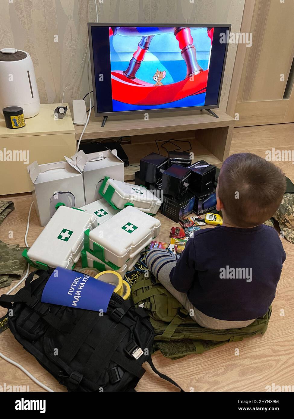 Child plays in video game in room with equipment for Ukrainian army ...