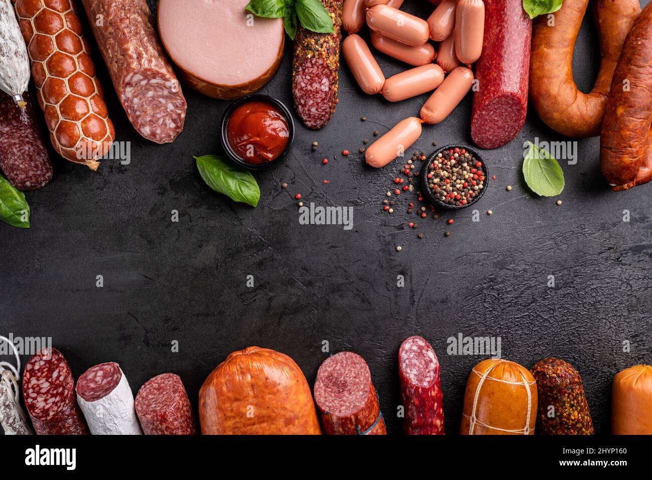 Set of different types of sausages, salami and smoked meat with basil ...