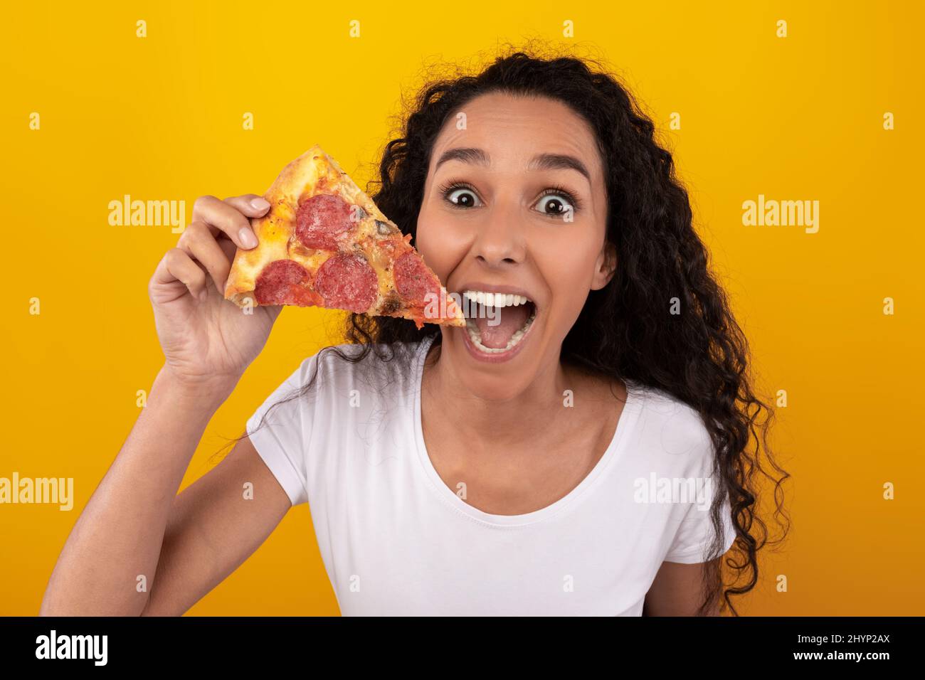 Happy Latin Lady Holding Pizza Slice At Studio Stock Photo - Alamy