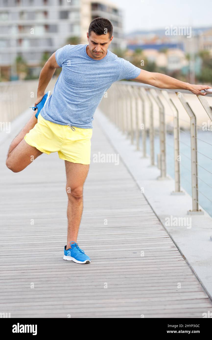 Positive male doing exercises on pier during morning workout Stock ...