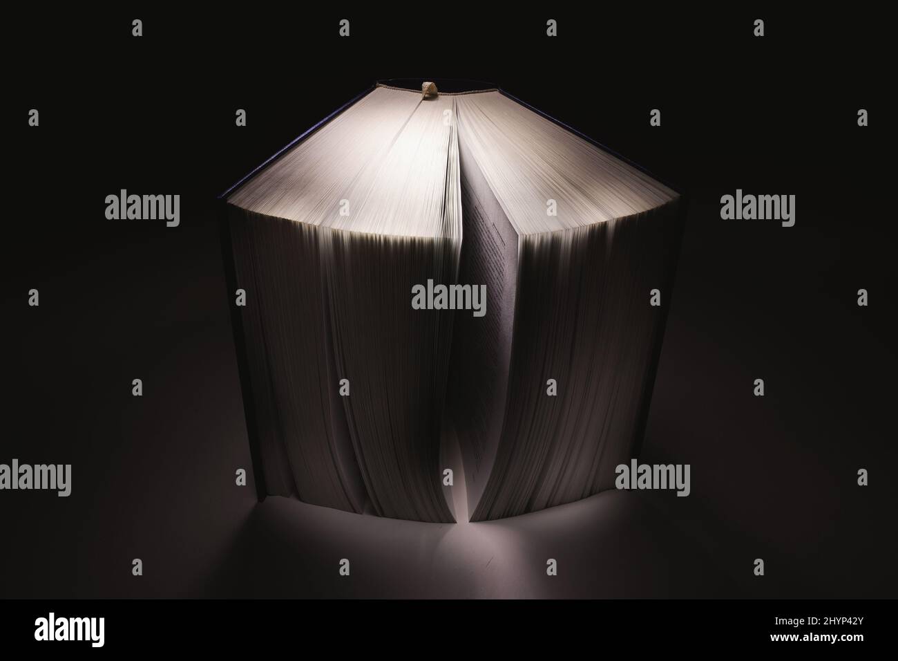One big thick book on white table in the dark Stock Photo - Alamy
