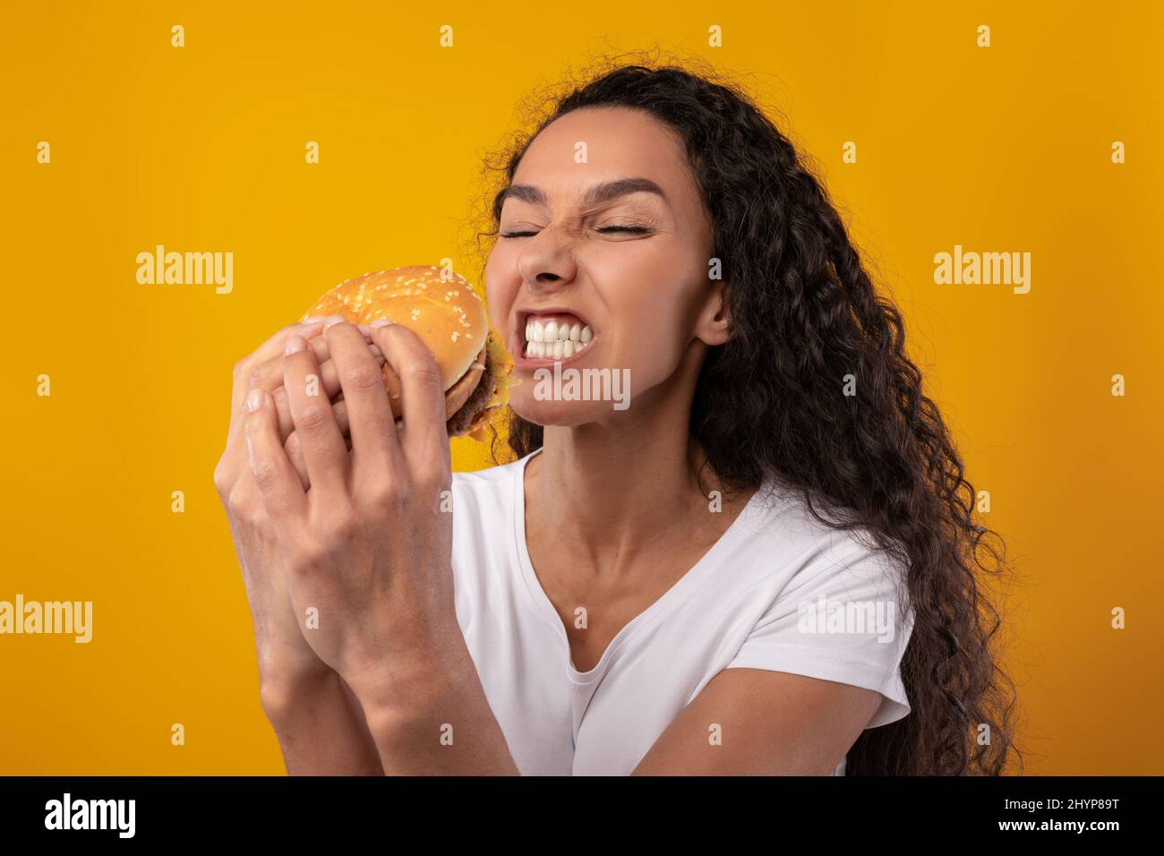 Hungry Lady Holding Burger Biting Sandwich At Studio Stock Photo - Alamy