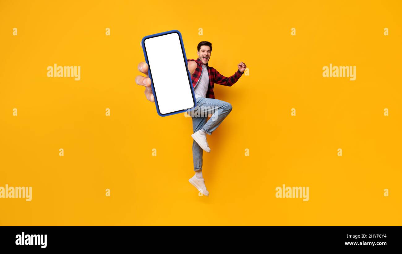 Cheerful guy showing empty smartphone screen gesturing yes Stock Photo ...