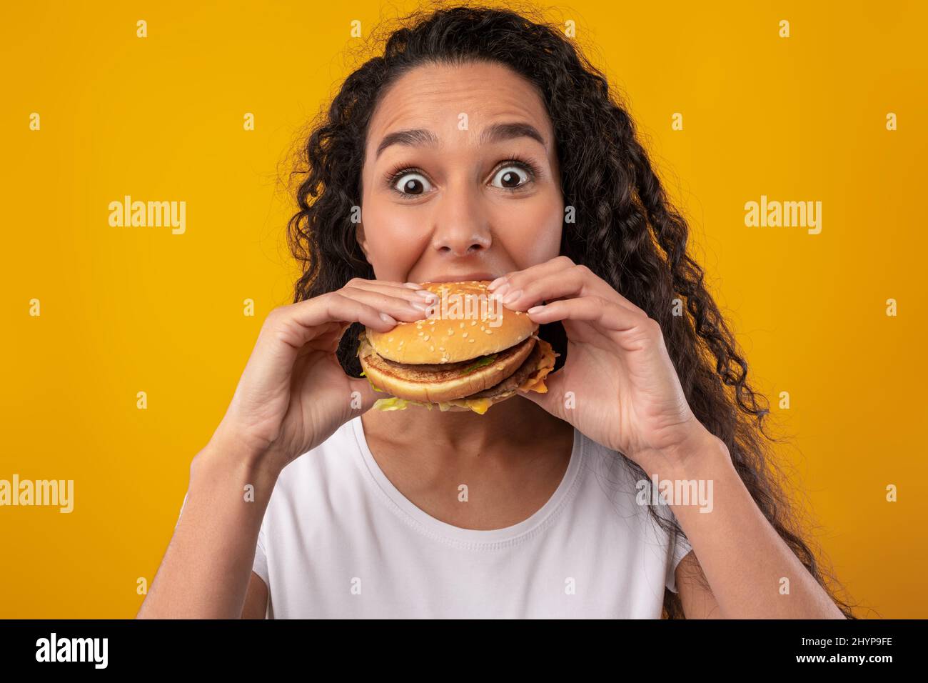 Hungry Lady Holding Burger Biting Sandwich At Studio Stock Photo - Alamy