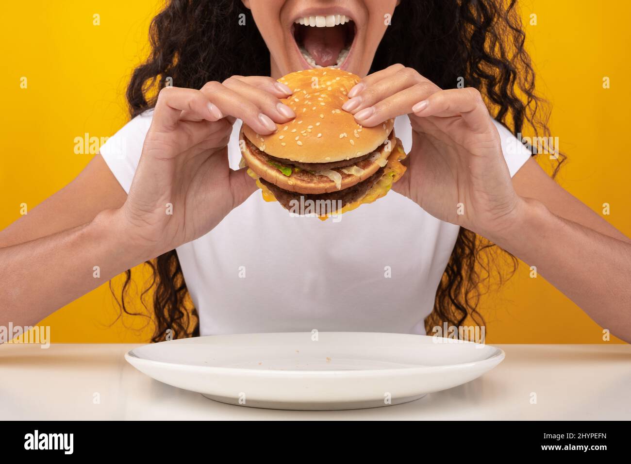 Closeup Of Lady Holding Burger Biting Sandwich At Studio Stock Photo ...