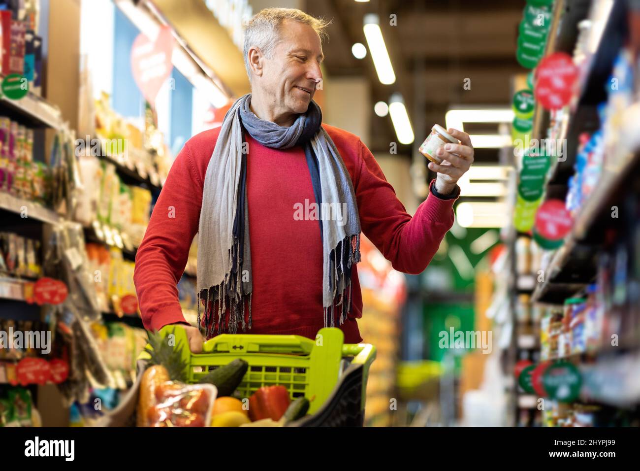 Positive senior man purchasing at supermarket alone Stock Photo - Alamy