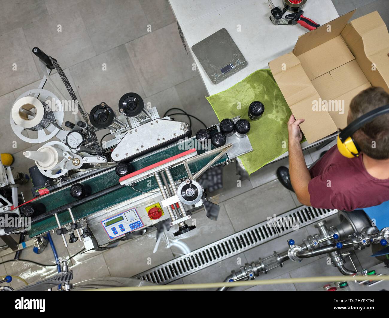 Worker at the end of a production line packing cans of beer to ship in ...