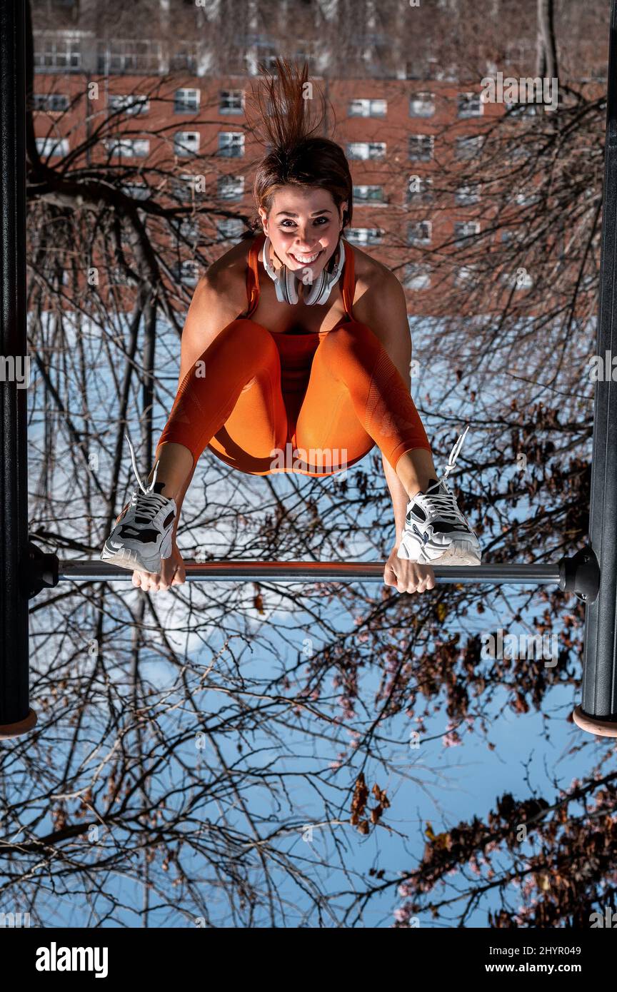 Attractive sporty woman with headphones around her neck doing ...