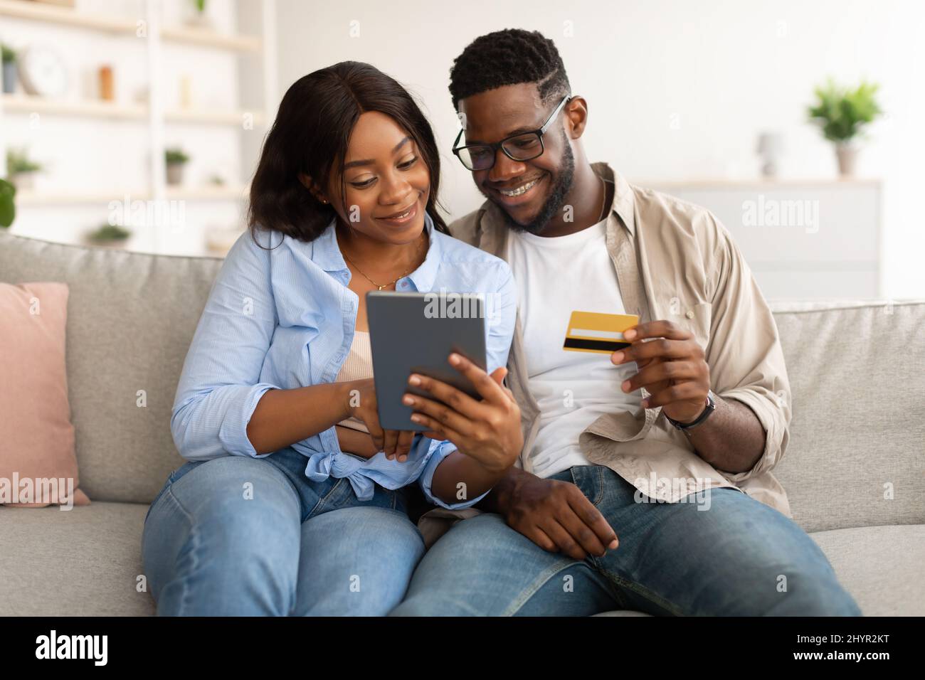 Black couple using tablet and debit credit card at home Stock Photo - Alamy