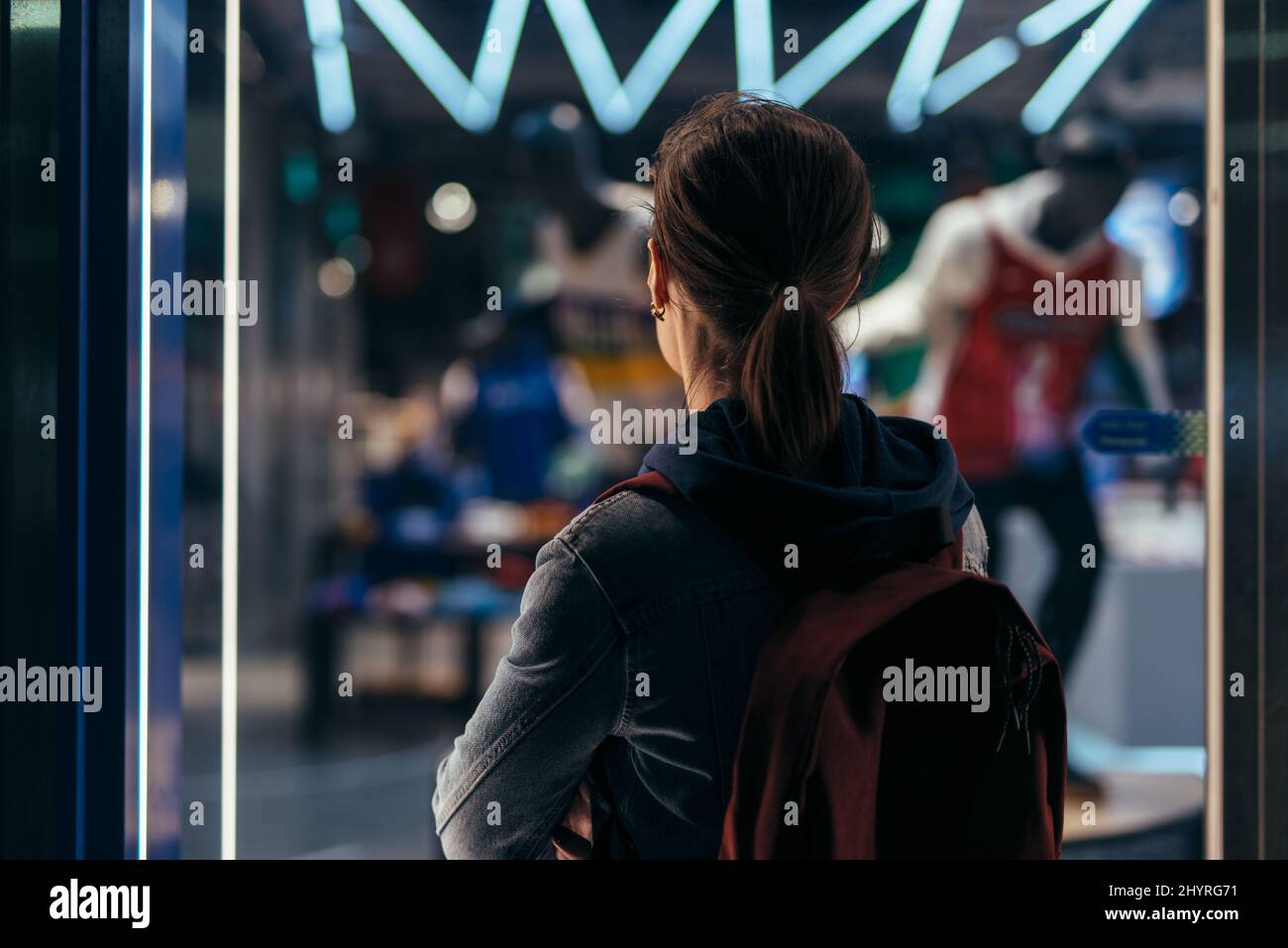 Woman looking through window store back hi-res stock photography and ...