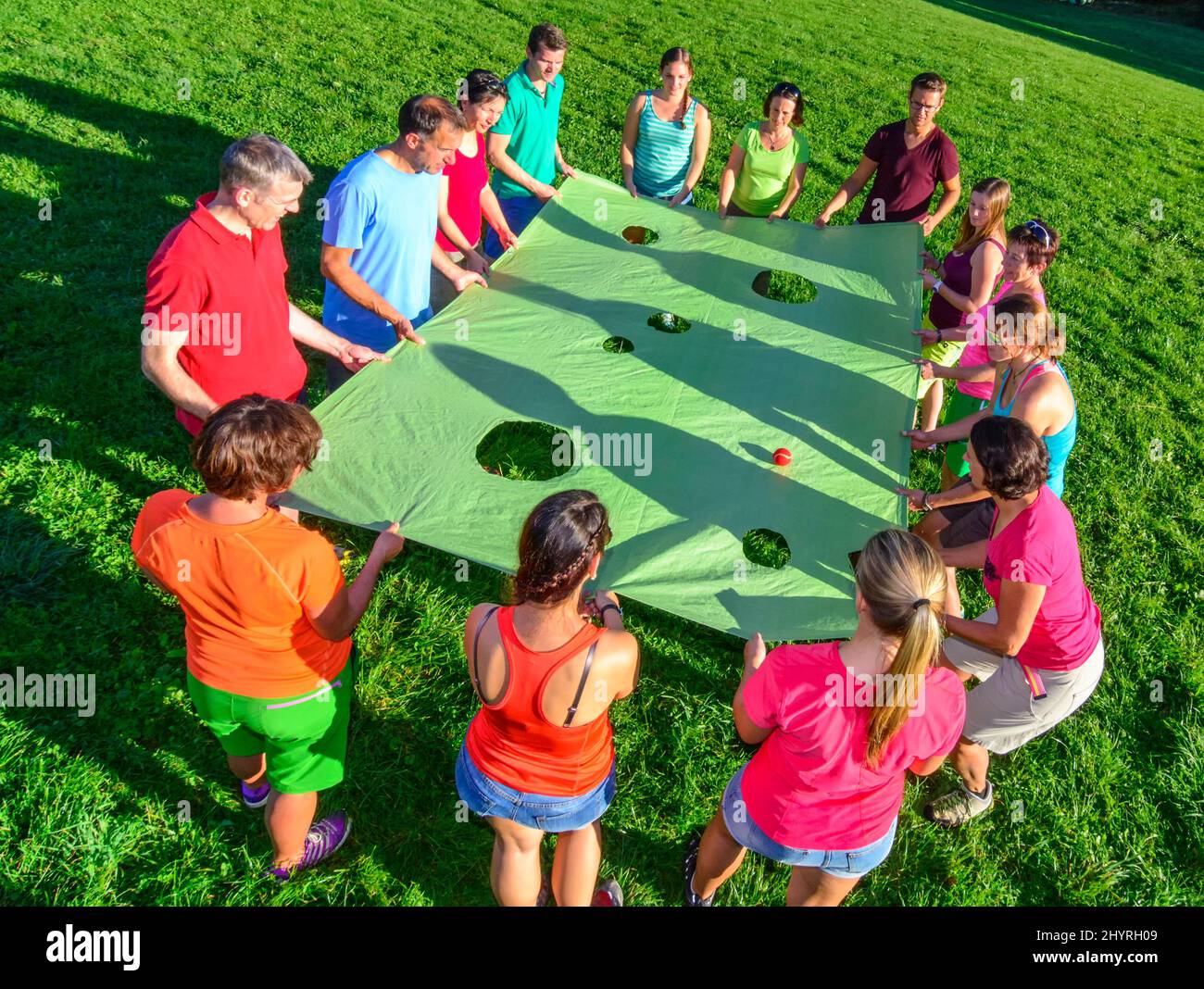 Team exercise - drop a ball into a hole together Stock Photo - Alamy