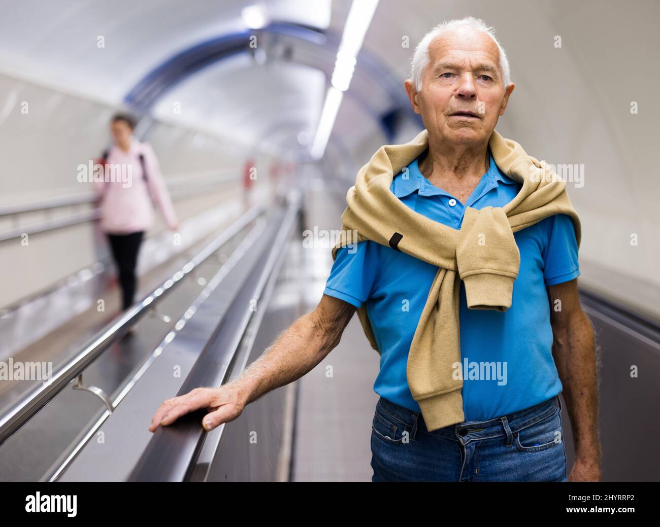Elderly man standing on moving walkway Stock Photo - Alamy