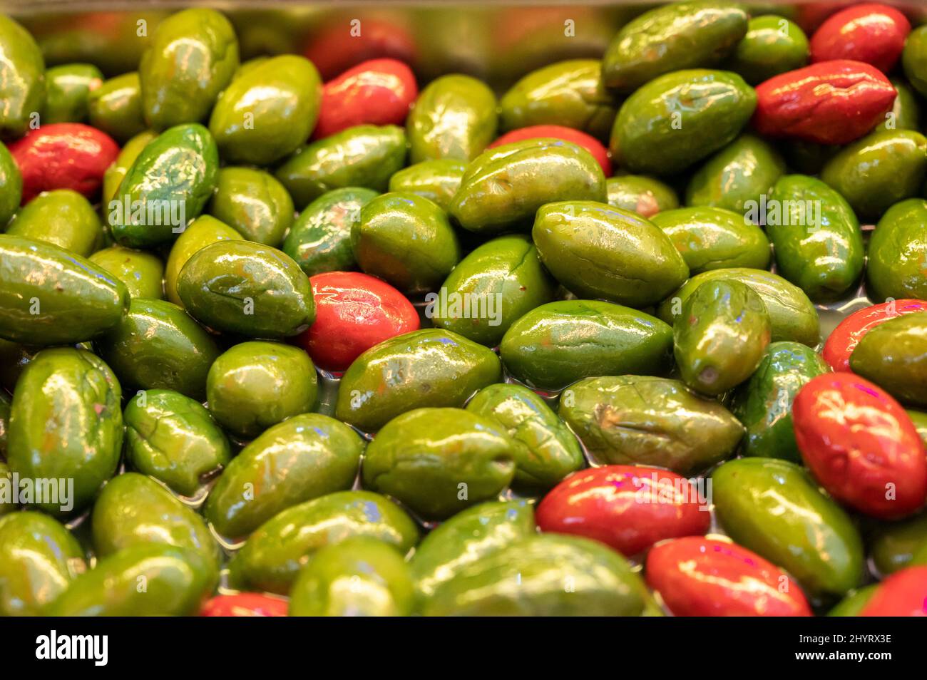Tasty green and red olives close up on market, healthy vegetarian food ...