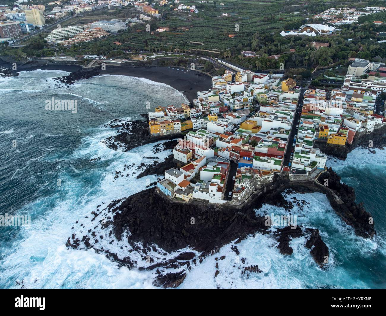 Aerial view on colorful houses and black lava rocks in small fisherman ...
