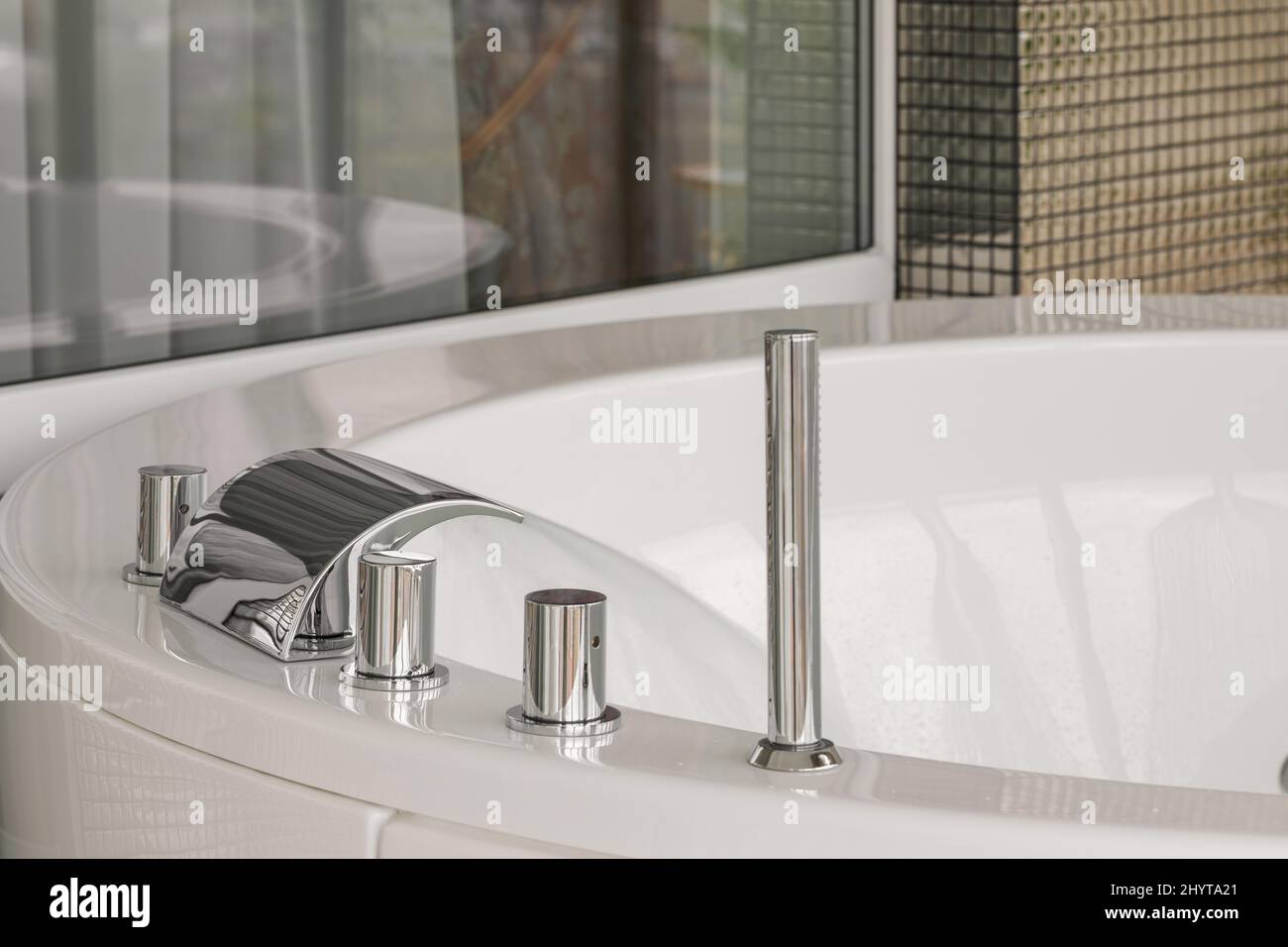 Water flows from a luxurious modern water faucet into a large modern ...