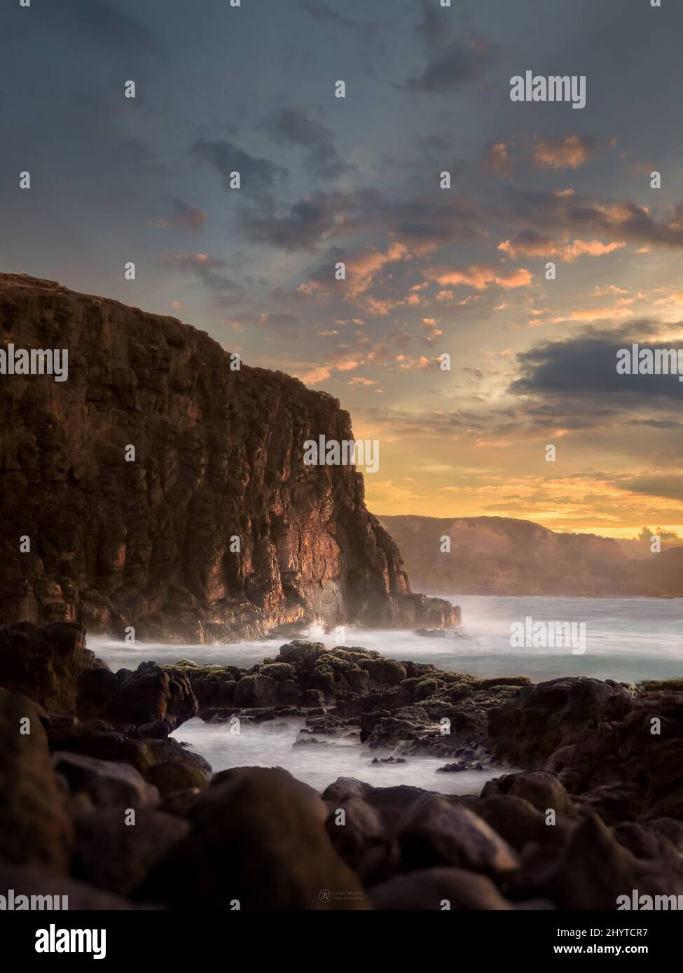 Early morning sunrise glow over the harsh rocks at Cape Schanck on the ...