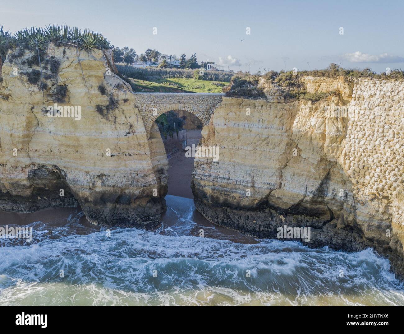 Old stone masonry Roman bridge in Praia dos Estudantes beach in Lagos ...