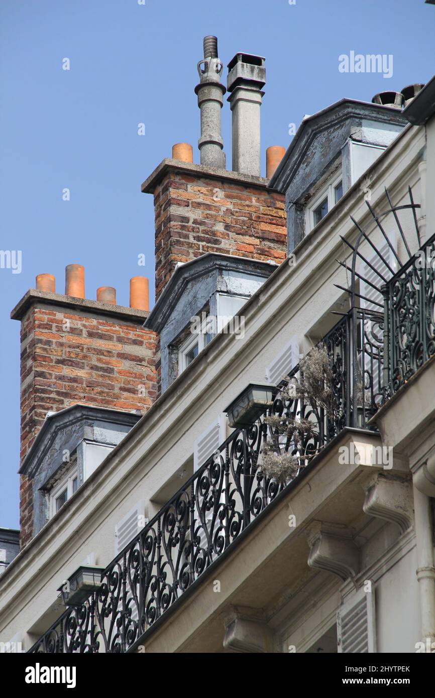 Vertical low angle shot of a building with balconies and chimneys in ...