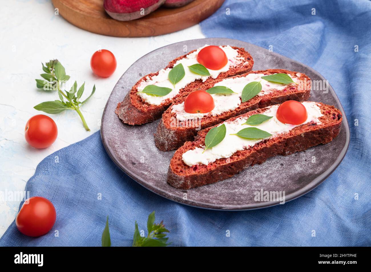 Red beet bread sandwiches with cream cheese and tomatoes on white ...