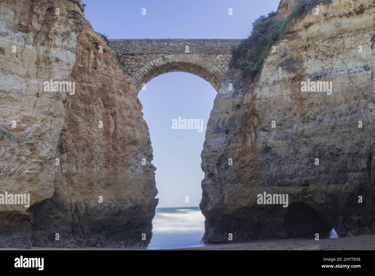 Old stone masonry Roman bridge in Praia dos Estudantes beach in Lagos ...