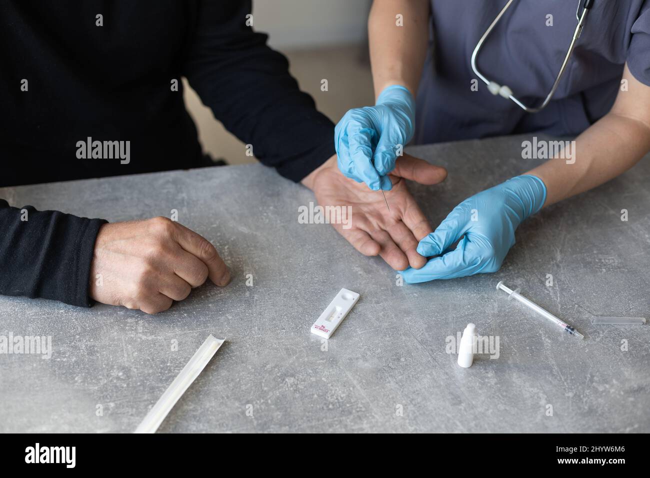 Nurse performing a coronavirus pcr test on an elderly man in his home ...