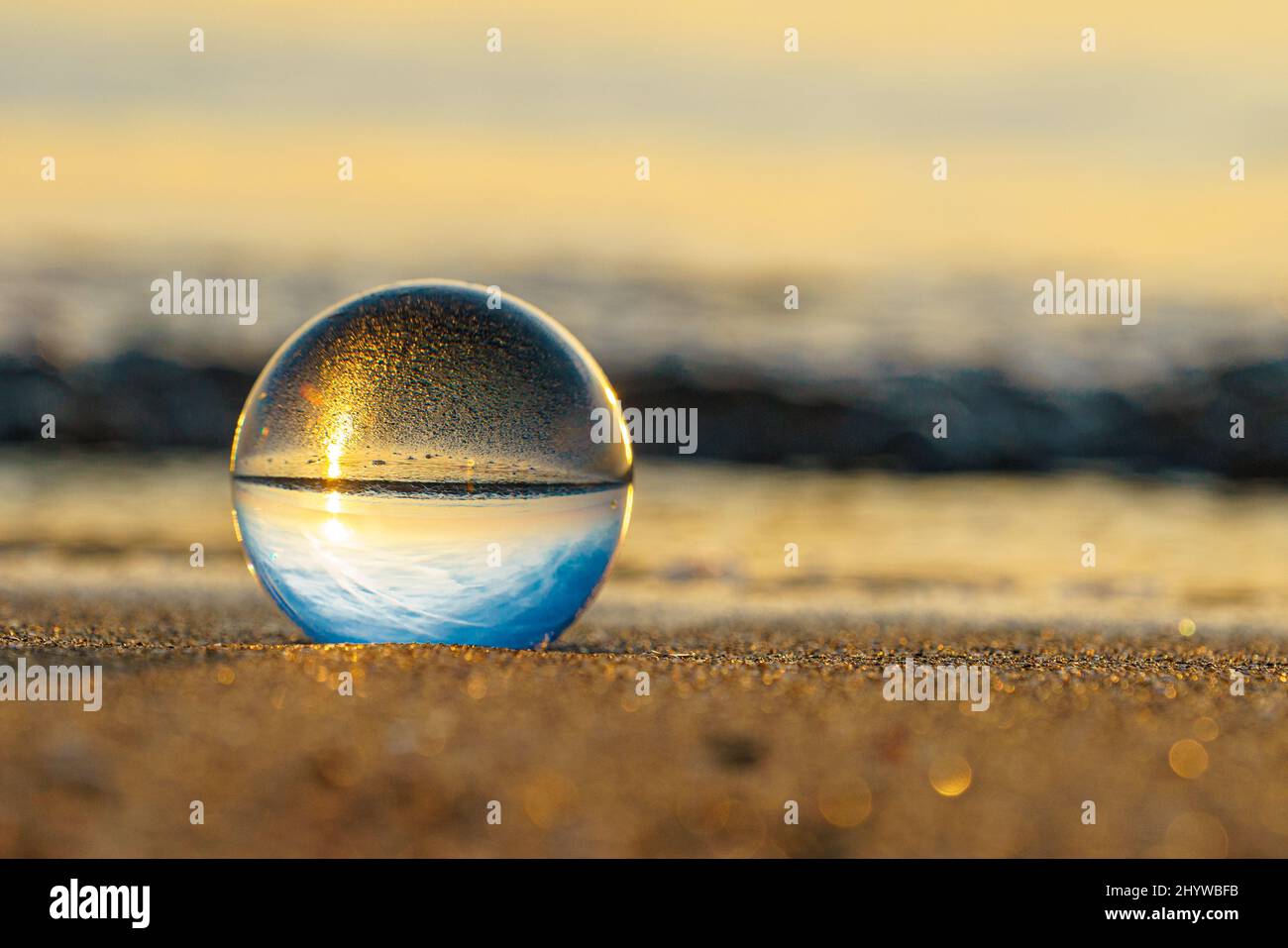 Closeup shot of a crystal ball with the reflection of the sea during ...